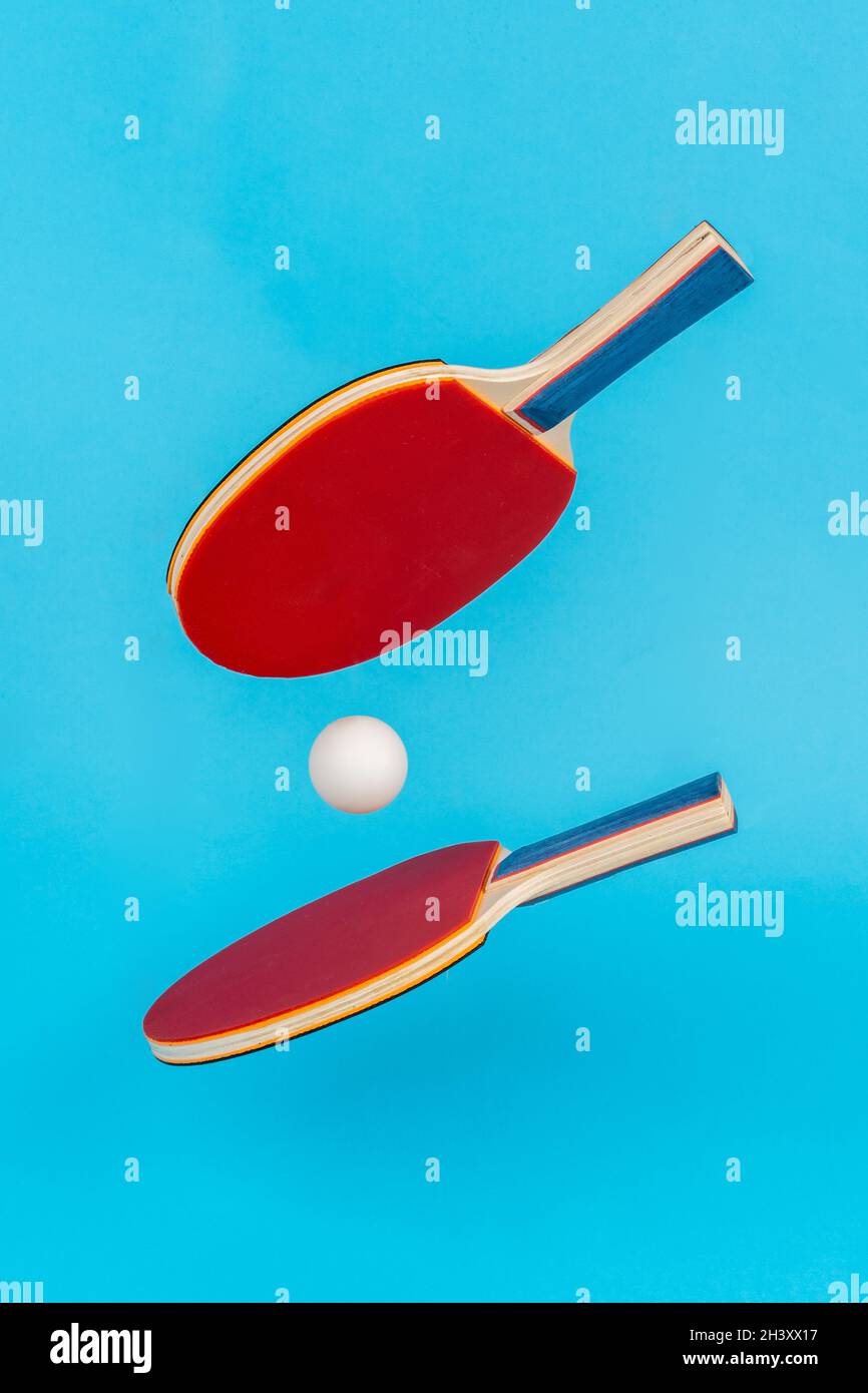 Red ping pong racket on a blue background Stock Photo - Alamy