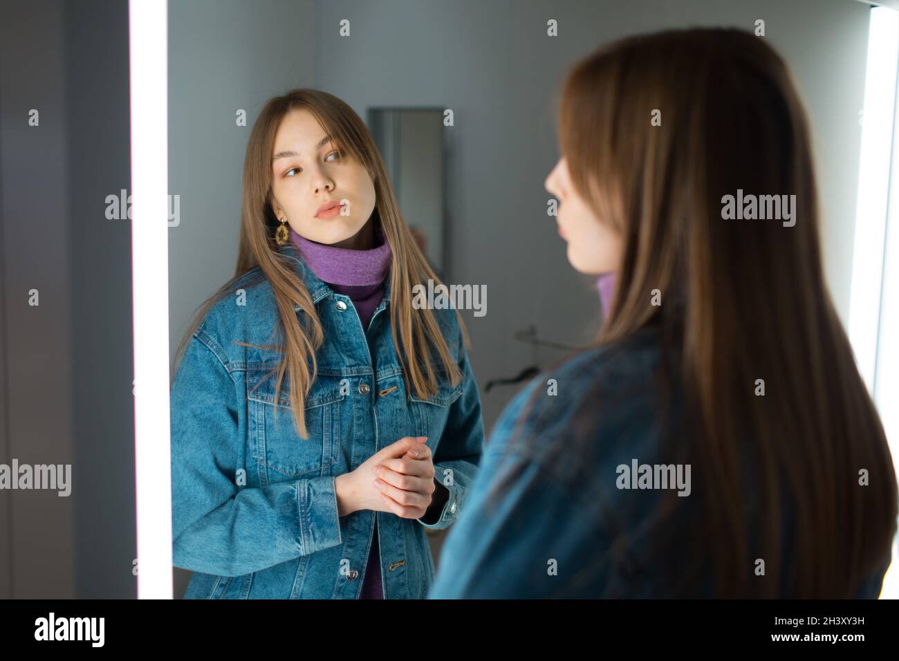 Young woman try on clothes in dressing room with mirror in shop Stock ...