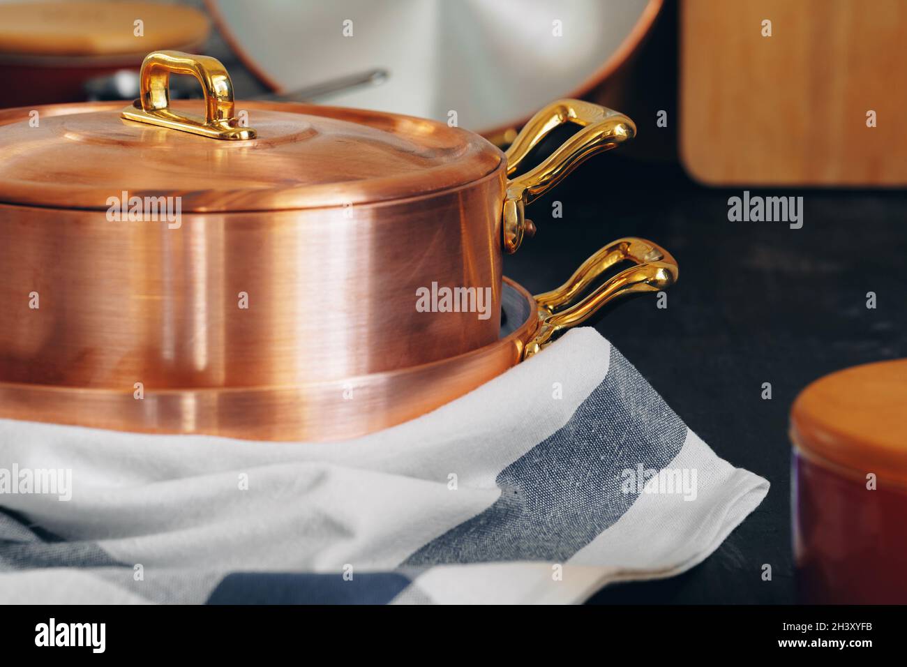Copper cookware with wooden kitchen utensils close up Stock Photo - Alamy