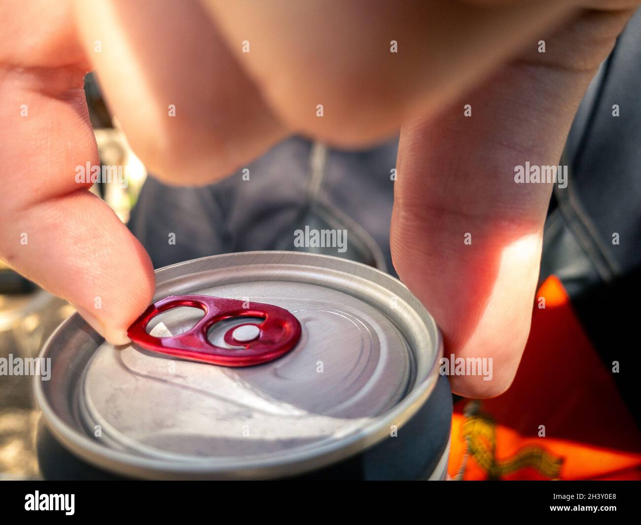 Closeup of hand man holding and opening pull tab of soda or beer can ...