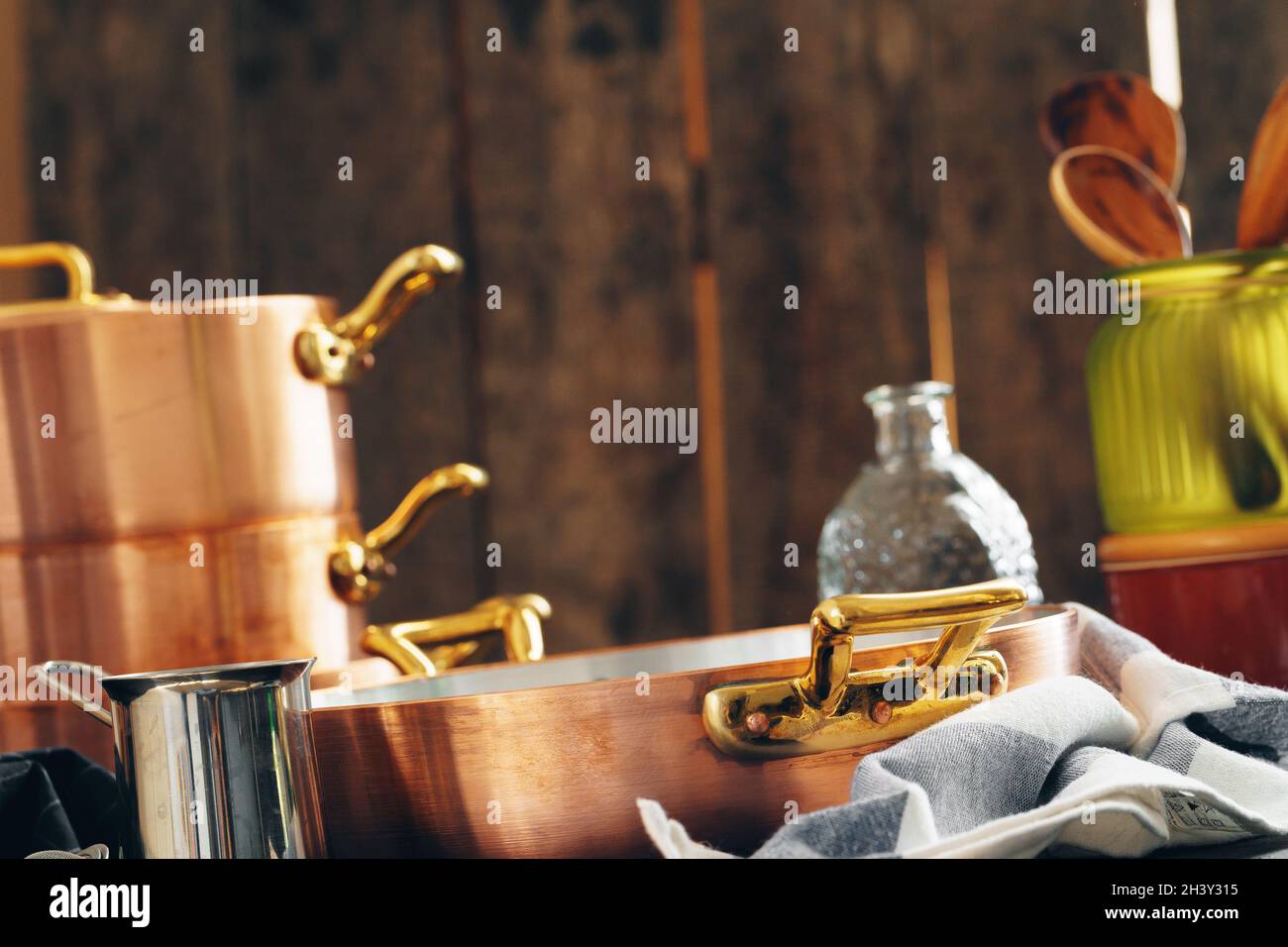 Copper cookware with wooden kitchen utensils close up Stock Photo - Alamy
