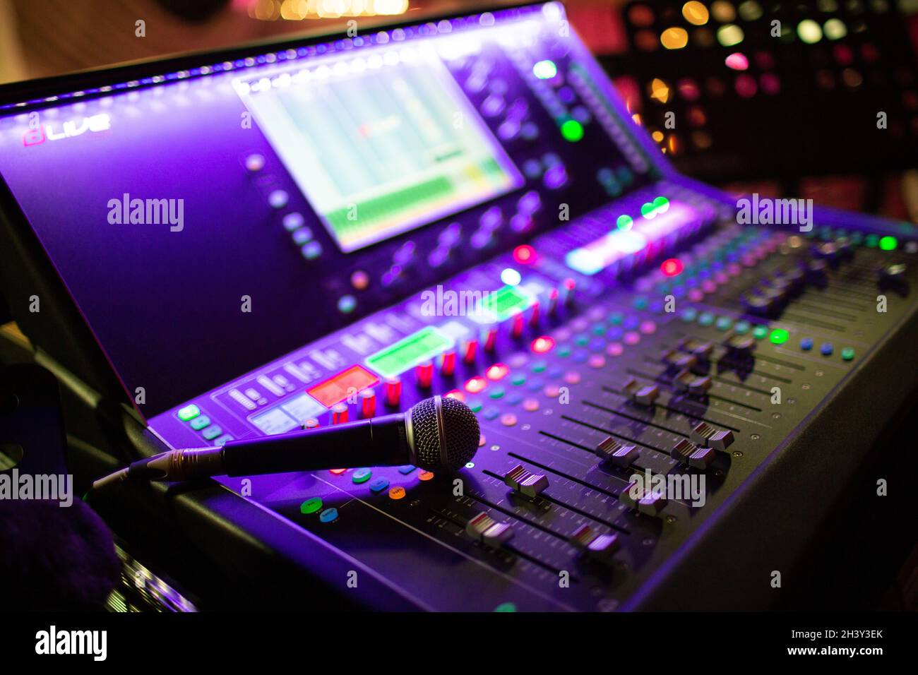Mixing console and microphone, hand equalizing audio sound channels in ...