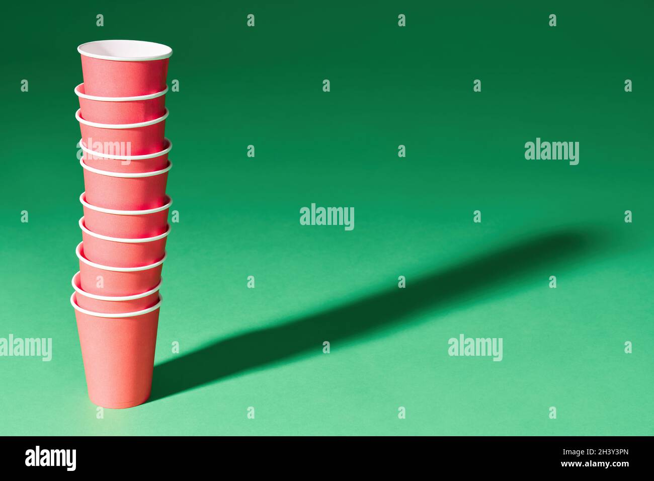 Stack of red paper cup on green background Stock Photo - Alamy
