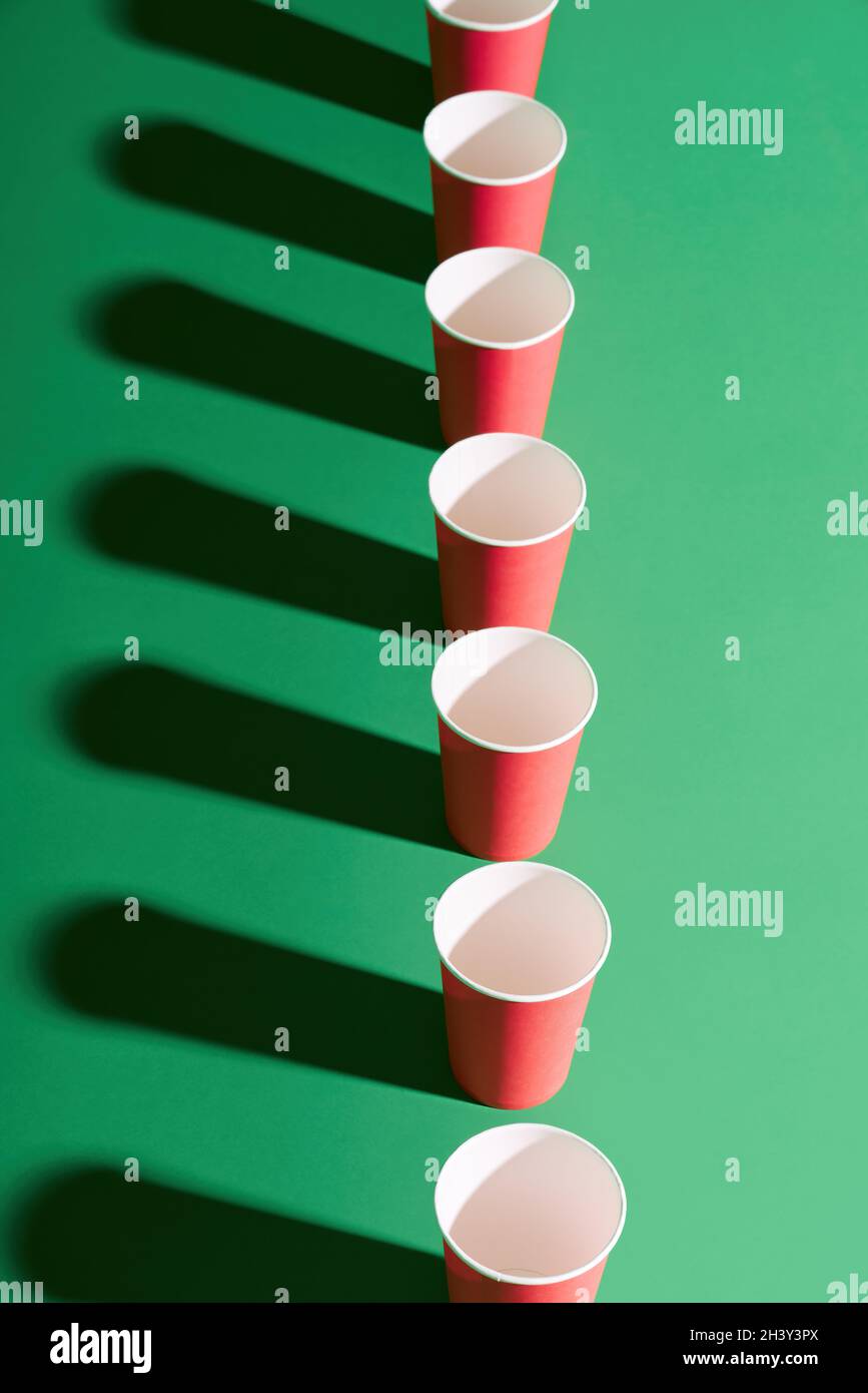 Top view of red paper cup in row on green background with shadows Stock ...