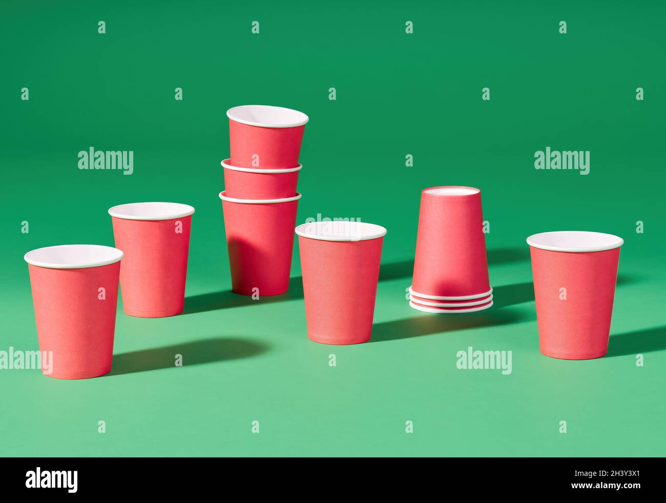 Set of red paper cups on green background Stock Photo - Alamy