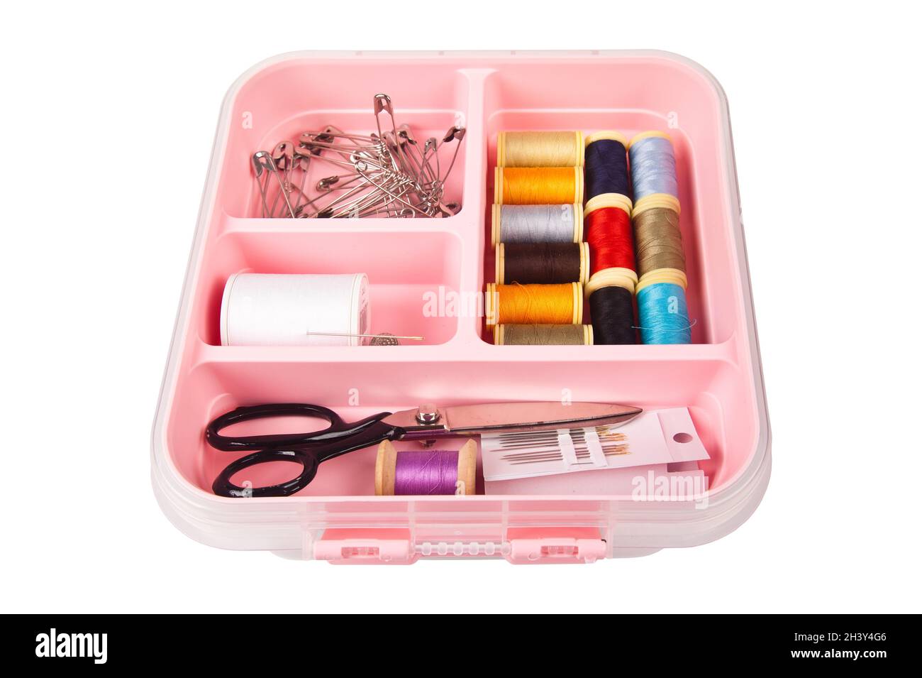There are threads scissors and needles in a pink plastic sewing box ...