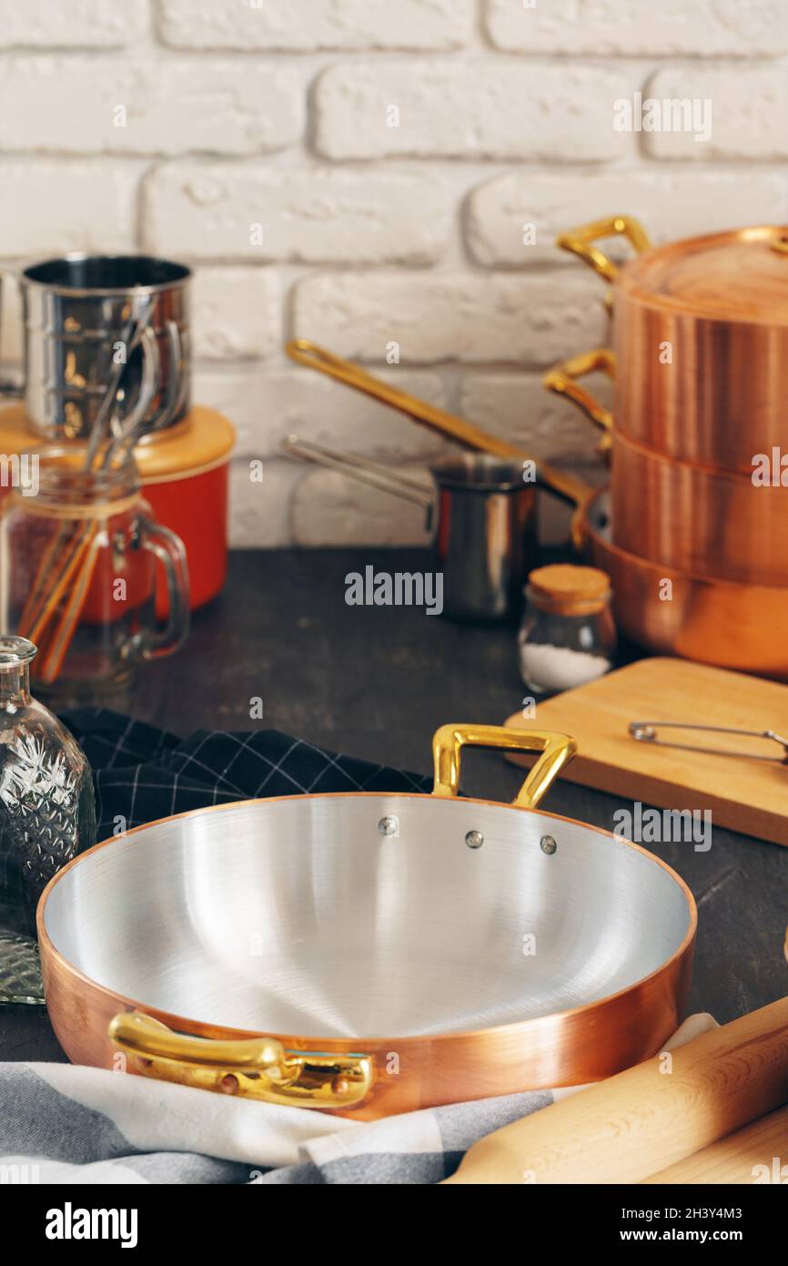 Copper cookware with wooden kitchen utensils close up Stock Photo - Alamy