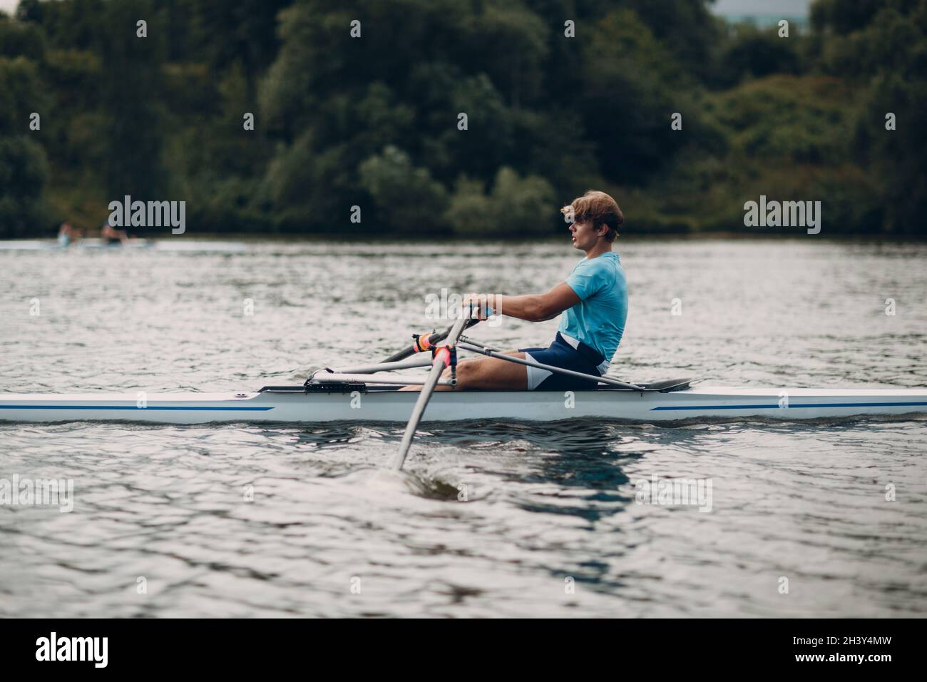 Sportsman single scull man rower rowing on boat Stock Photo - Alamy