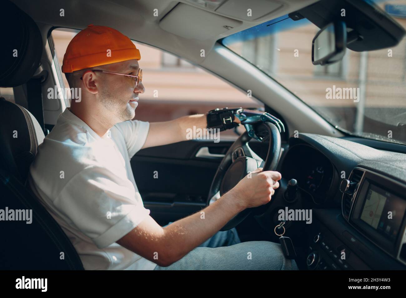 Young disabled man driver with artificial prosthetic hand driving ...
