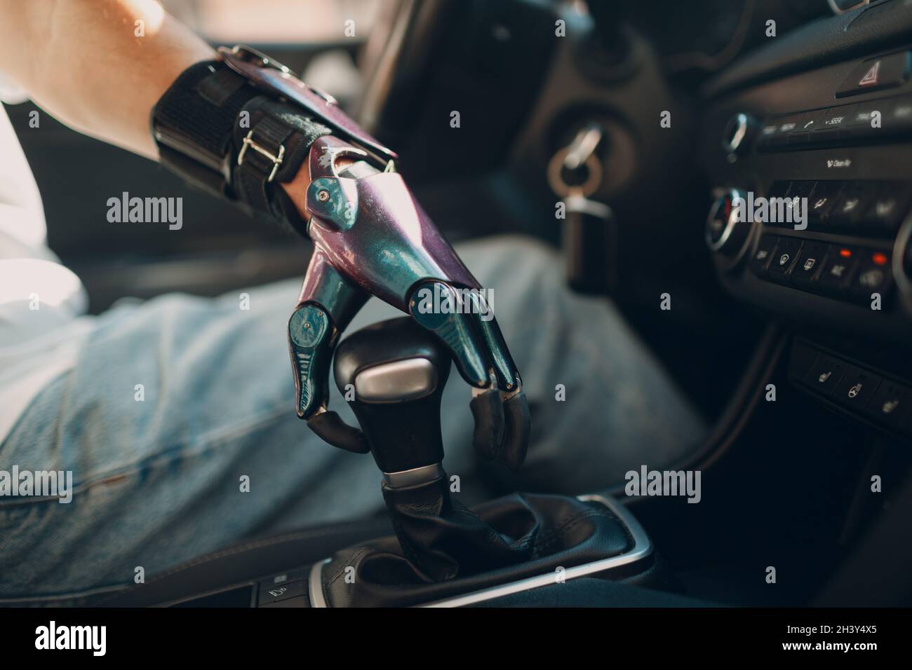 Young disabled man driver with artificial prosthetic hand driving ...