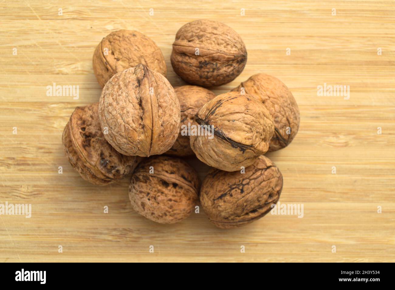 Healthy and nutritious beige brown walnut grains, bamboo on cutting ...