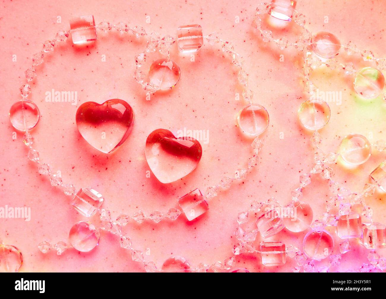 Transparent hearts and beads on marble in pink tone. Perfect Valentine ...