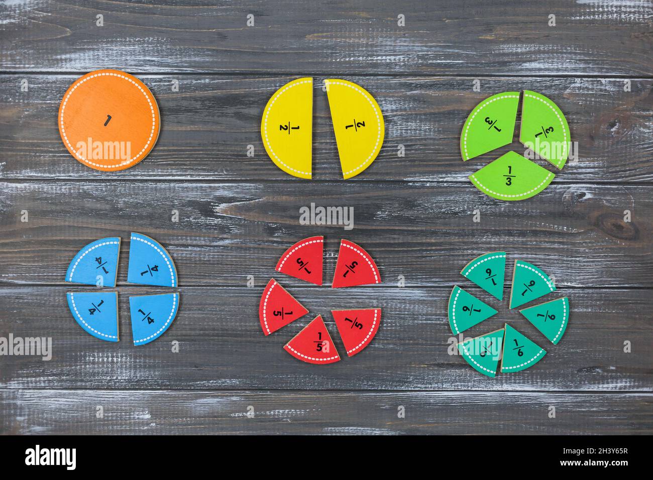 Multicolored fractions, blocks, notebook on a gray wooden table. Back ...