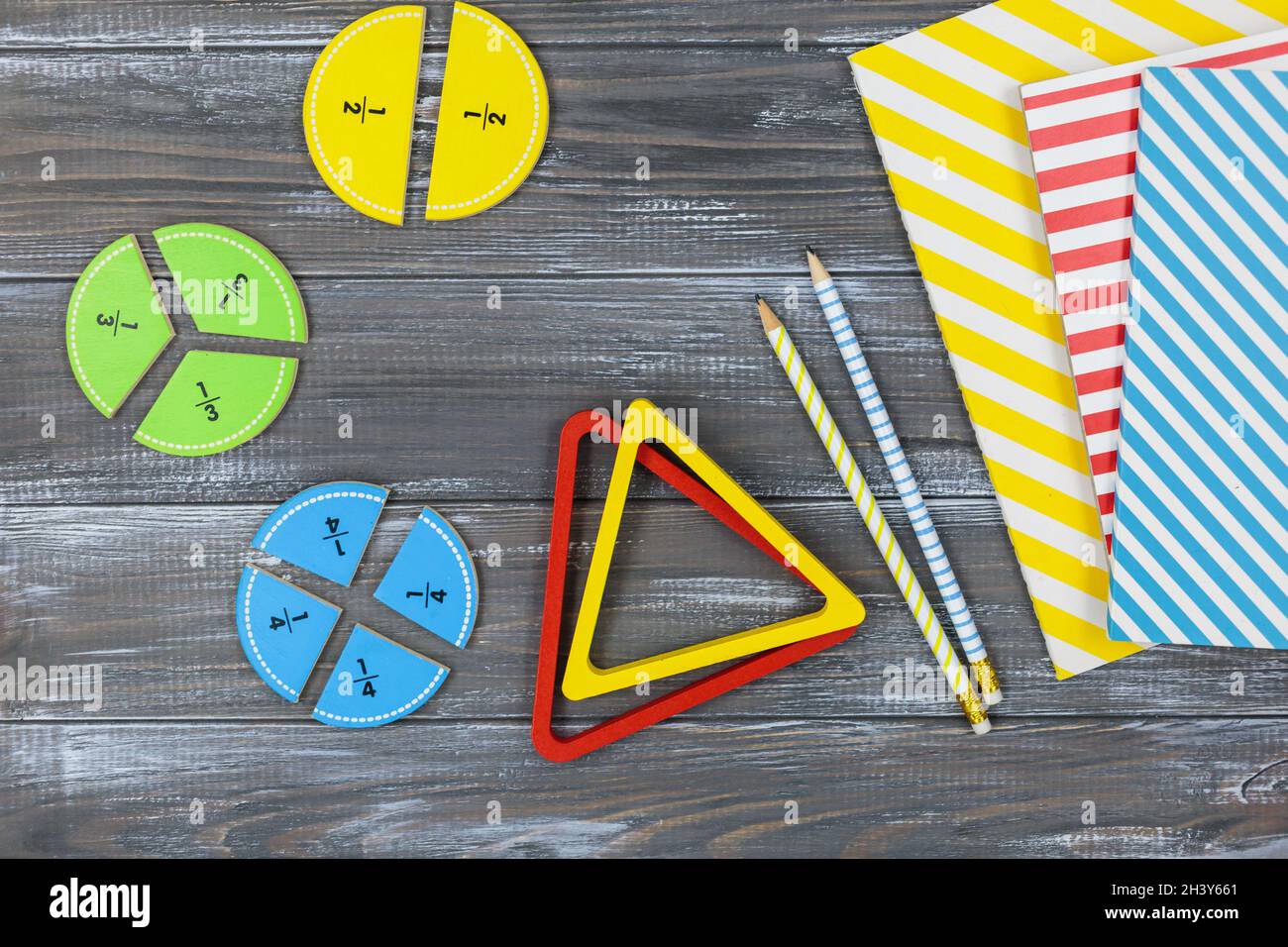 Multicolored fractions, blocks, notebook on a gray wooden table. Back ...