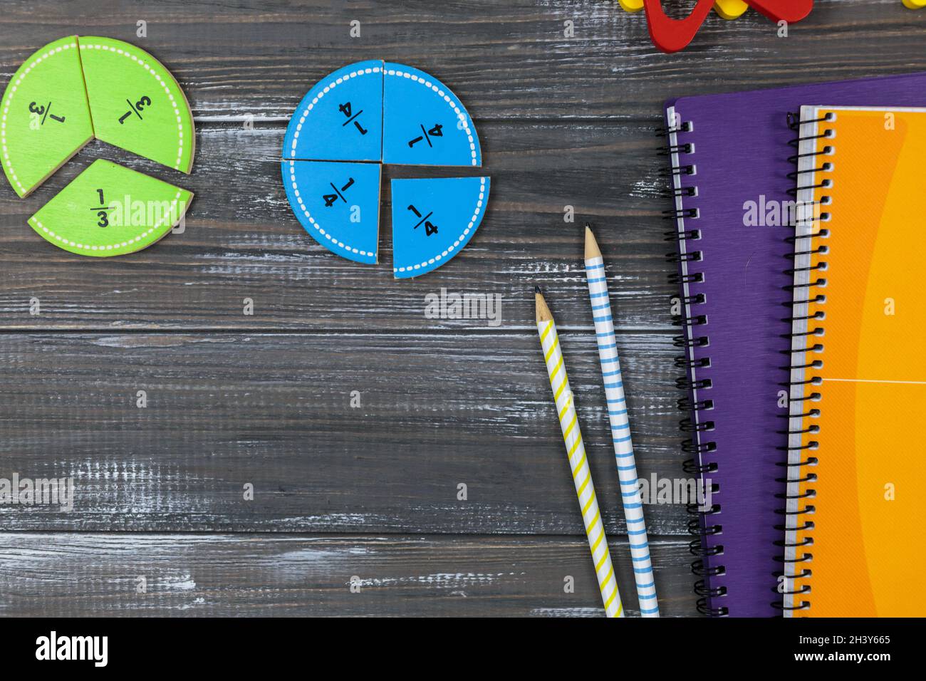 Multicolored fractions, blocks, notebook on a gray wooden table. Back ...