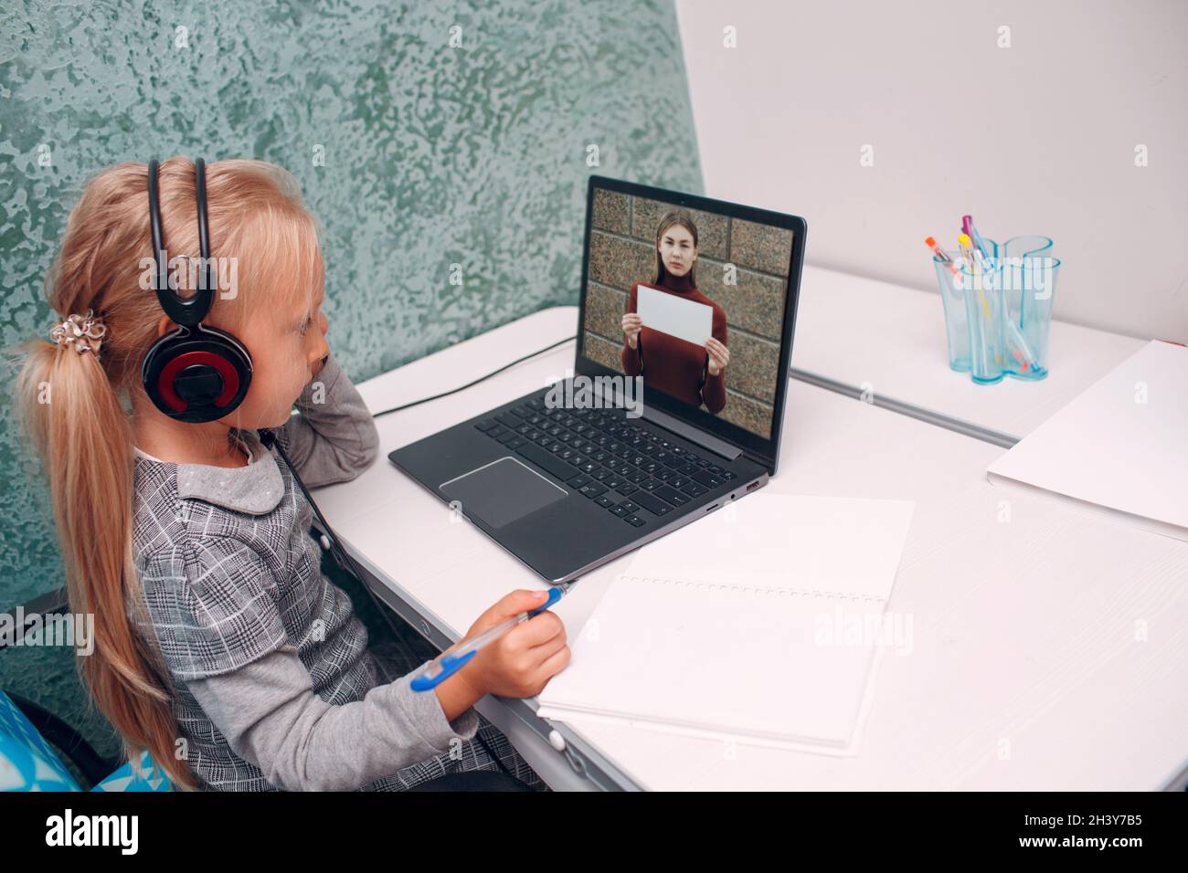 Young student little girl with tacher holds white poster with quadratic ...