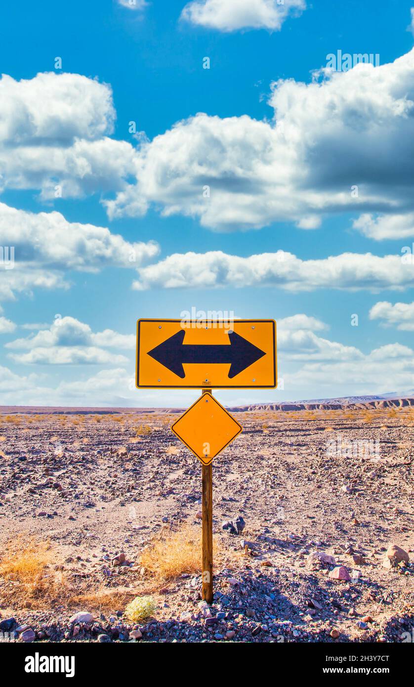 Directional sign in the desert with scenic blue sky and wide horizon ...
