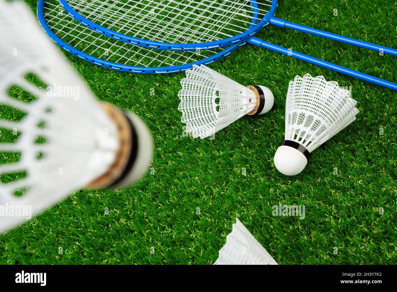 Badminton game rackets and shuttlecock on grass Stock Photo - Alamy