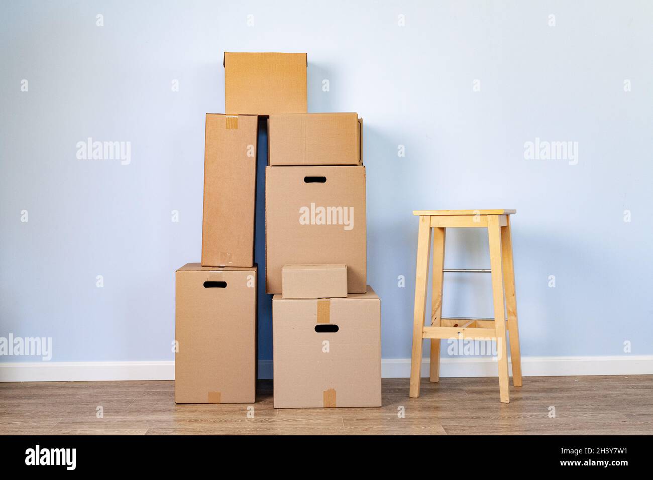 Moving boxes with packed stuff and chair for moving Stock Photo - Alamy