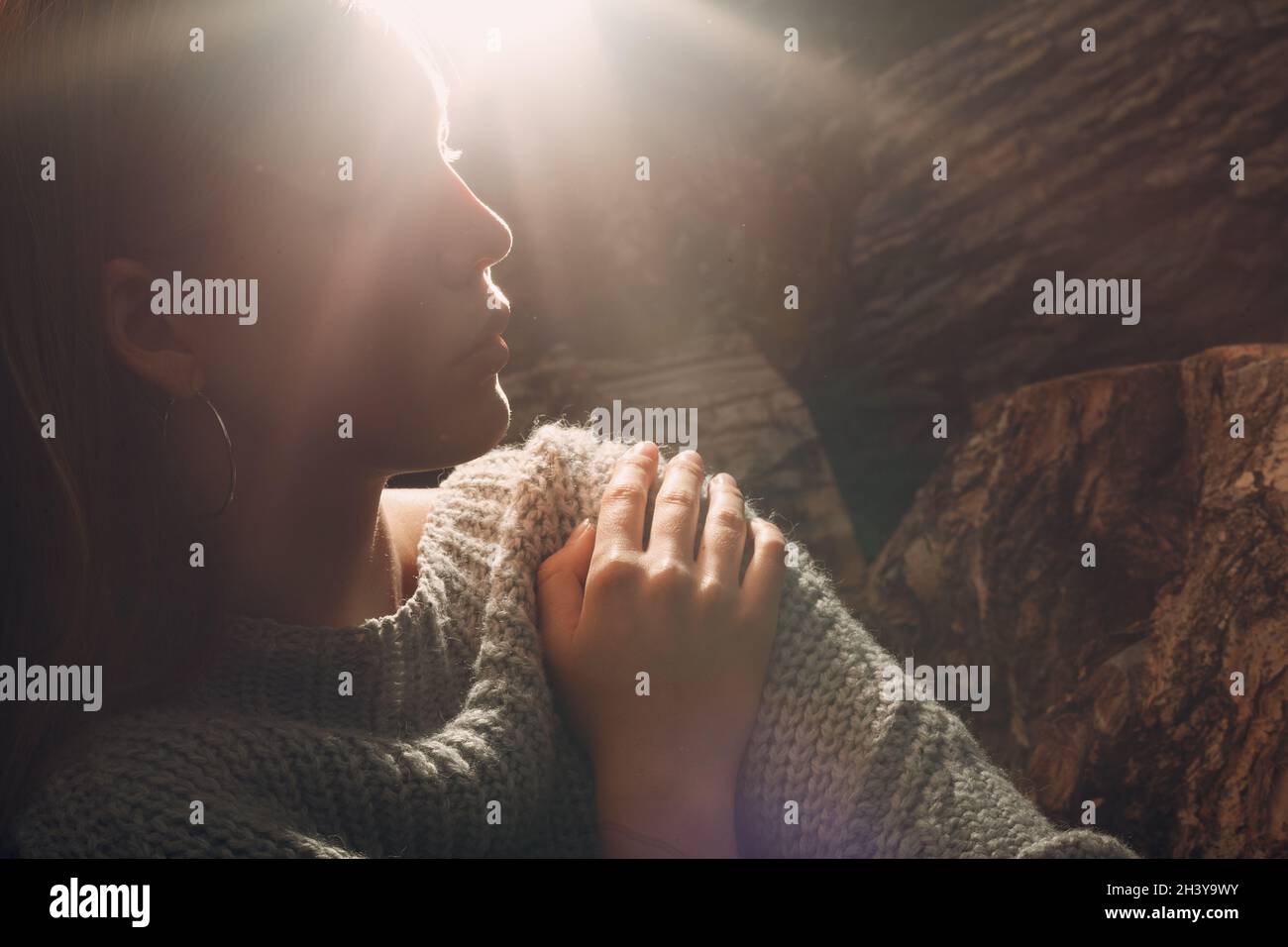 Sunlight and Pretty young woman with hand on shoulder outdoor in the ...