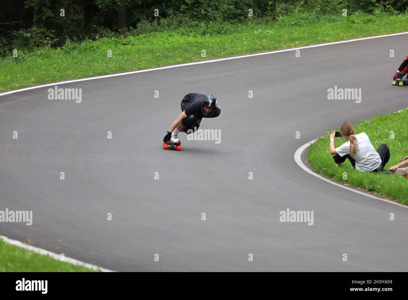 Longboard competition, athletes on the track in the middle of a forest ...