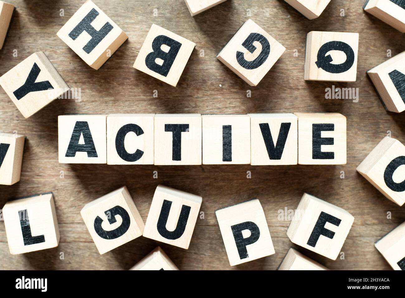 Alphabet letter block in word active with another block on wood ...
