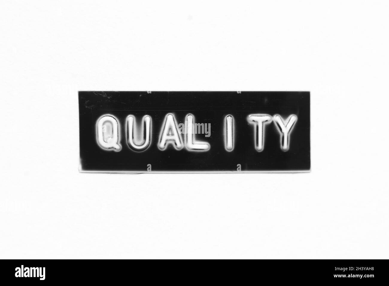 Black color banner that have embossed letter with word quality on white ...