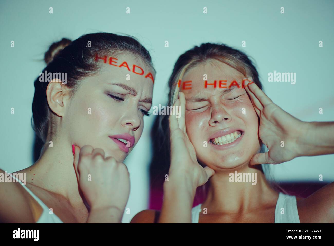 Young adult women holds hands on head ad having suffering facial ...