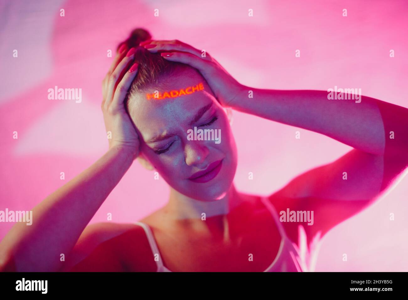 Young adult woman holds hands on head ad having suffering facial ...