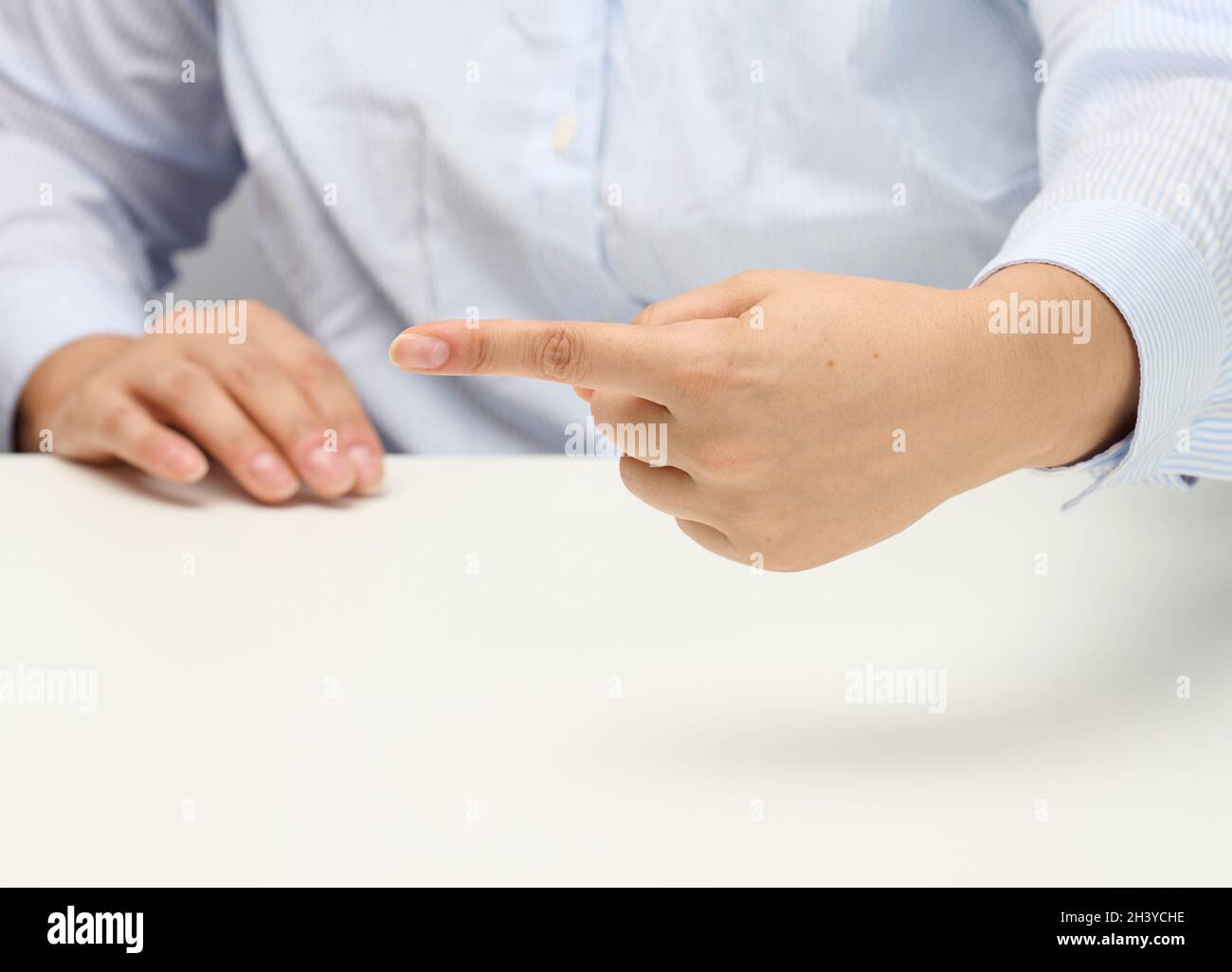 Female hand with forefinger. Part of the body points to the side ...