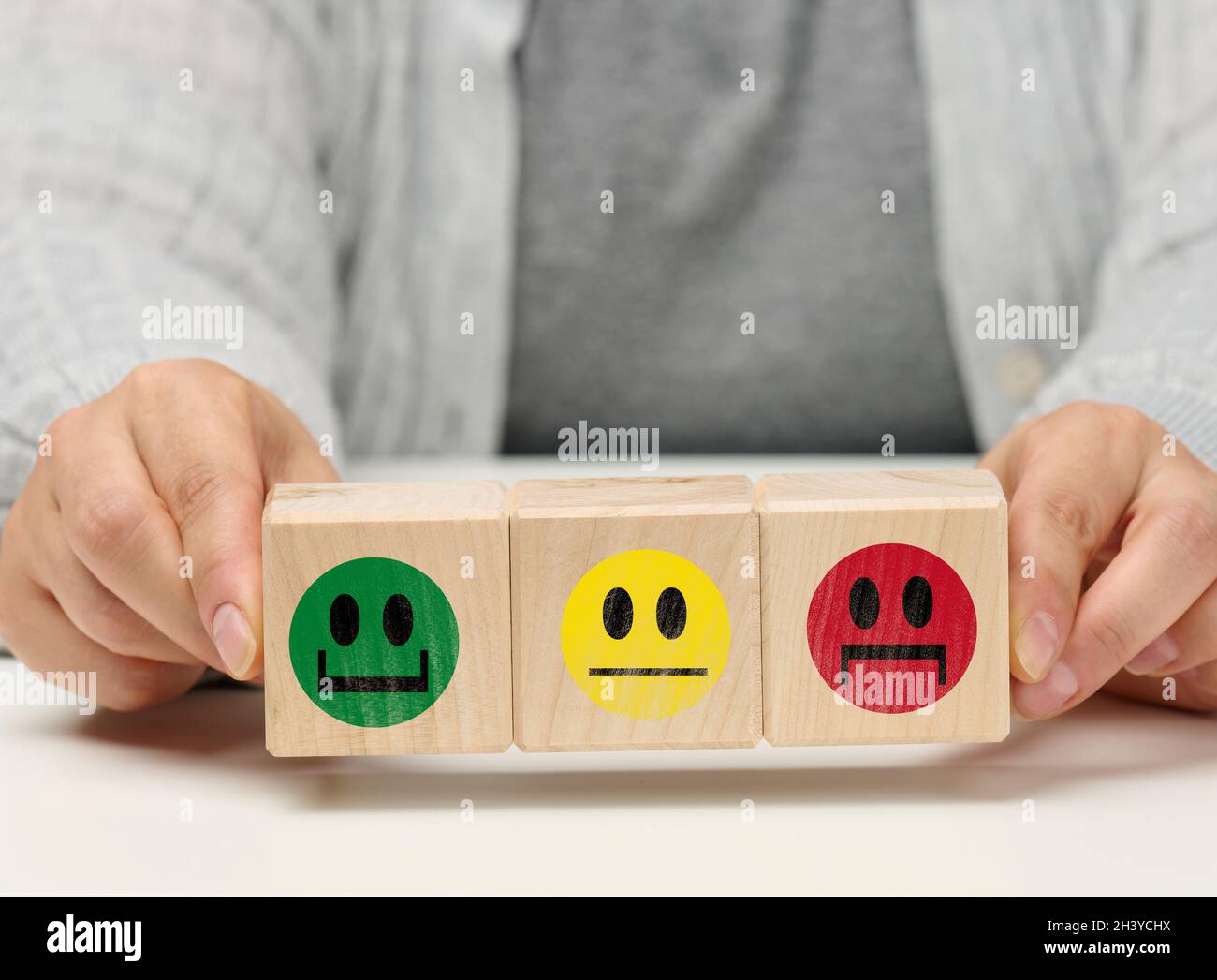 Wooden blocks with different emotions from smile to sadness and a woman ...