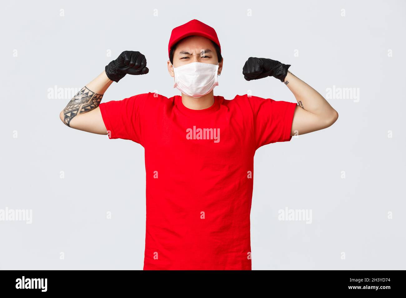 Strong asian delivery guy in red cap, t-shirt show-off his strength ...