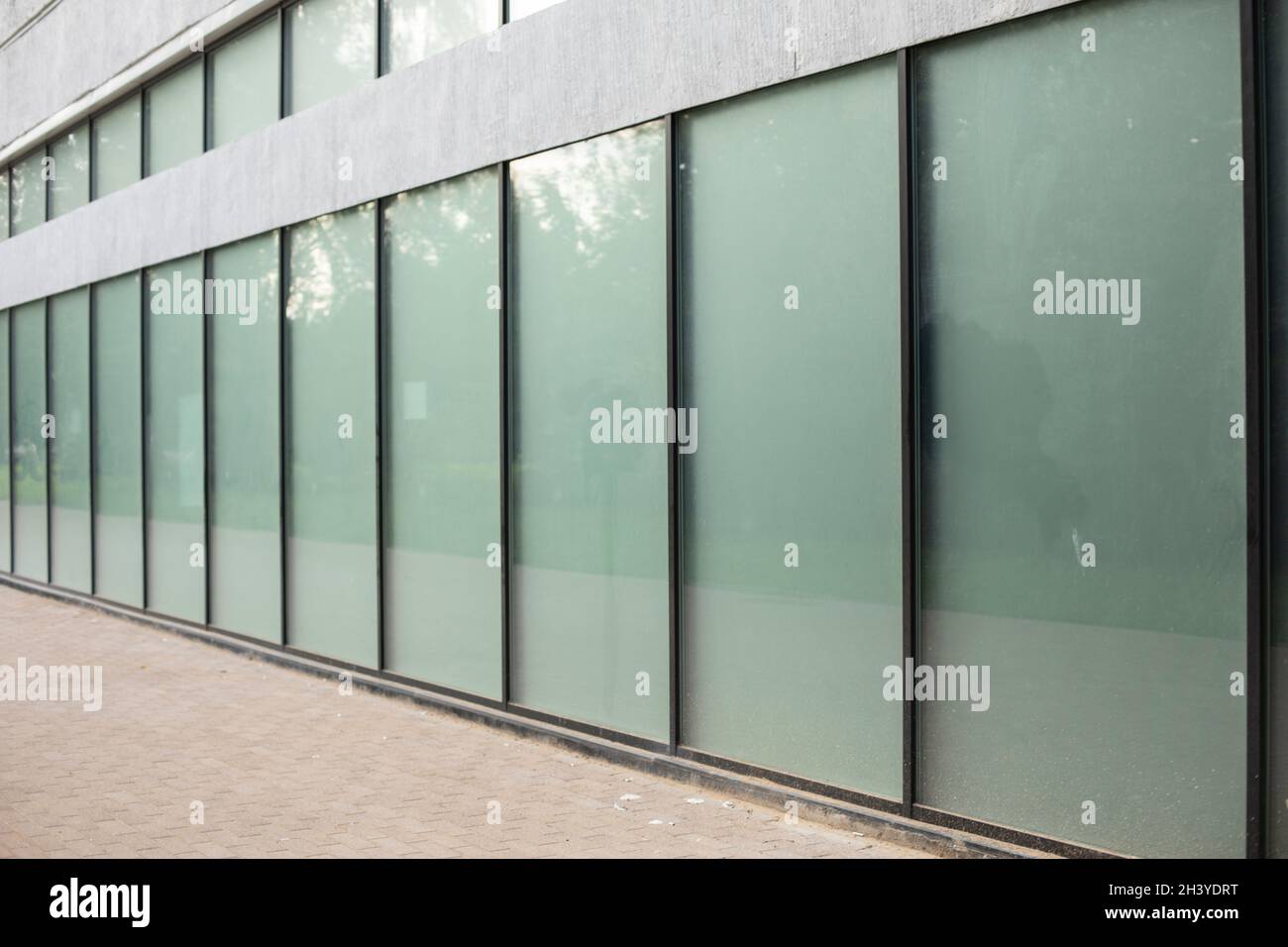 Facade glass in a long house. A row of window frames. Shop window ...