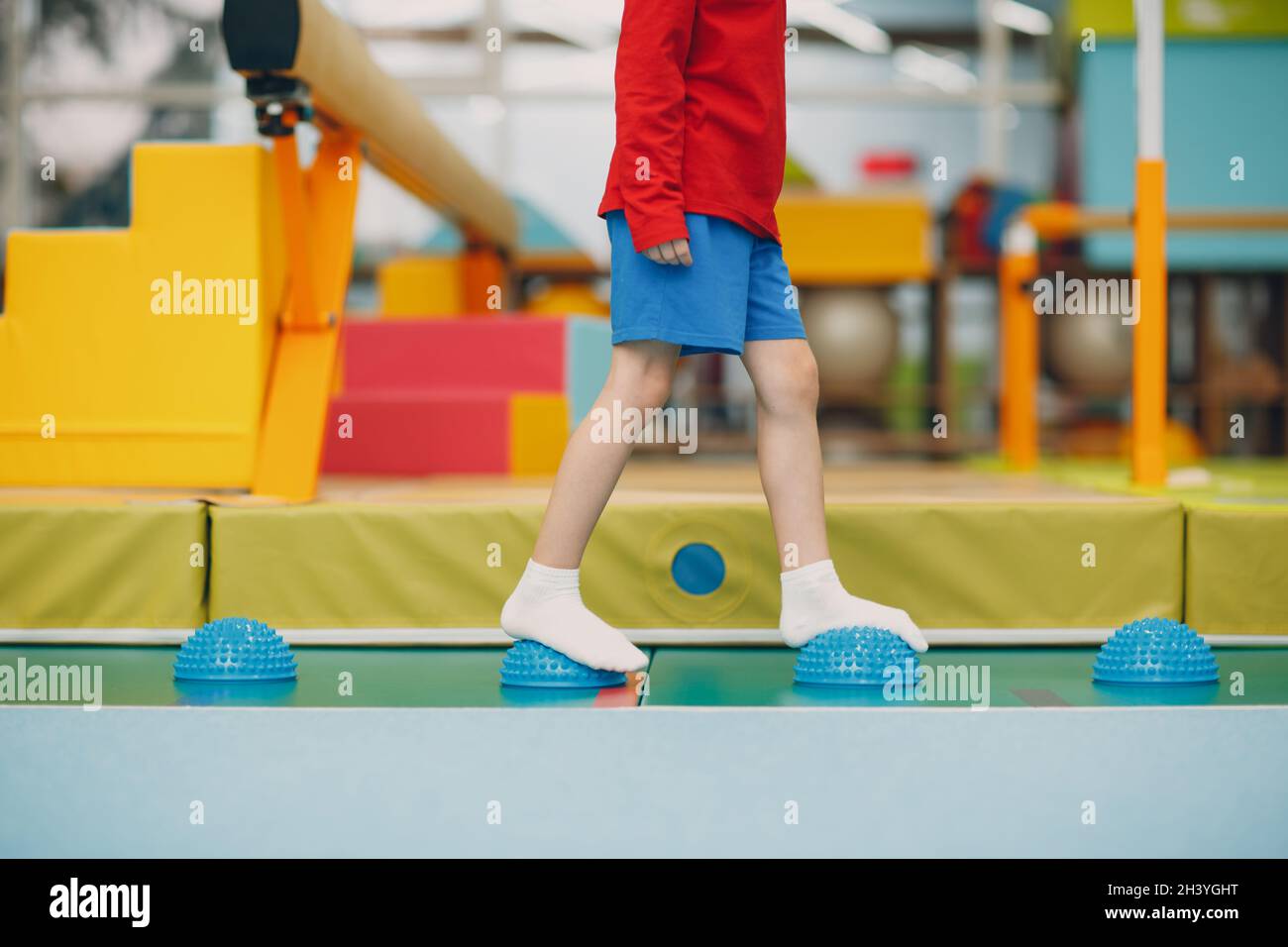 Kids doing massage hedgehog for foot legs exercises in gym at ...