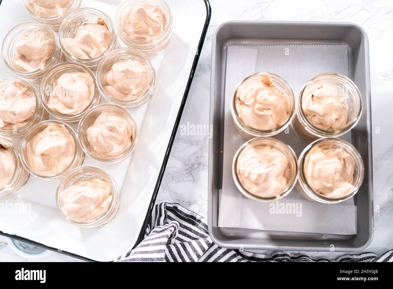 Scooping mixture into the small glass jars to make homemade chocolate ...