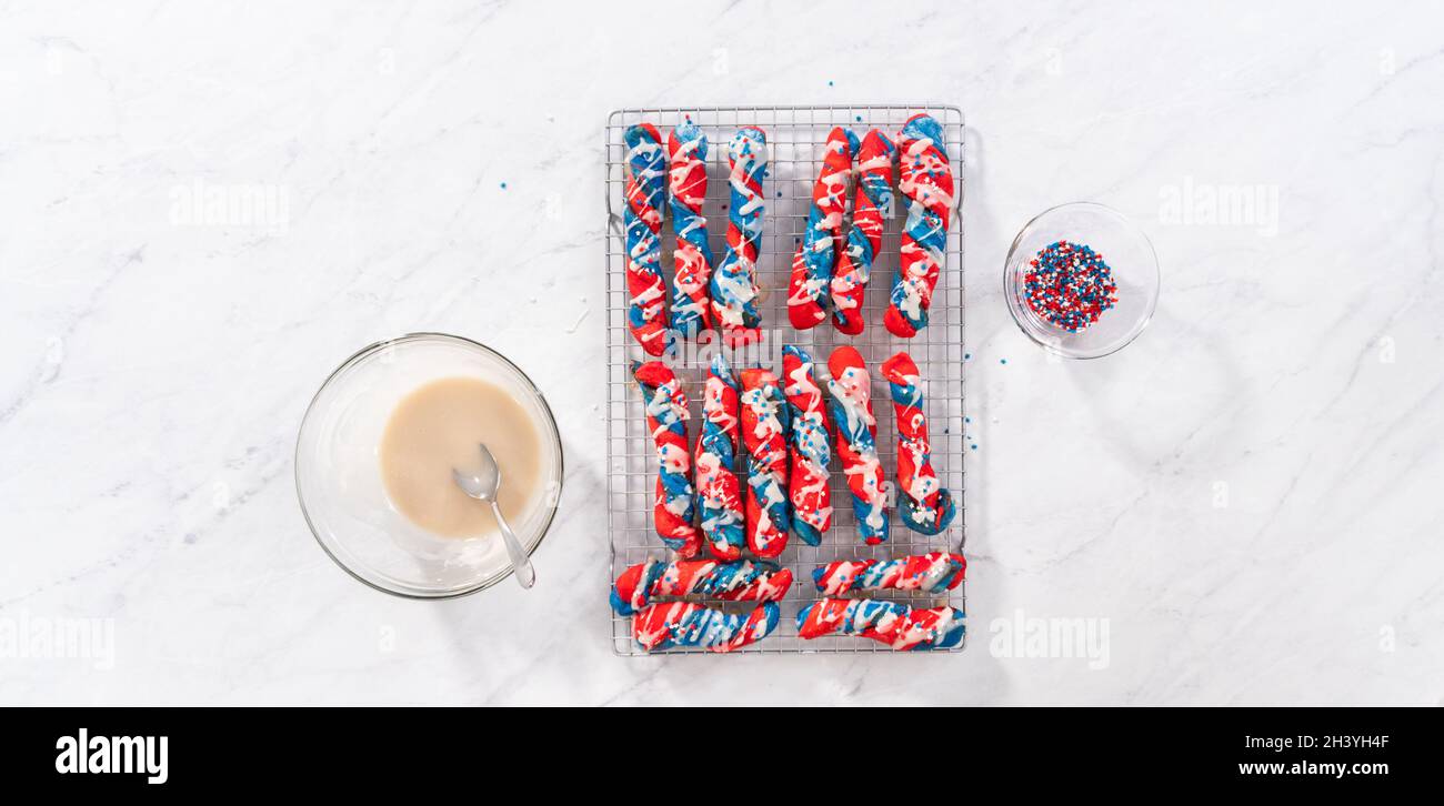Flat lay. Drizzling white glaze on top of patriotic cinnamon twists and ...
