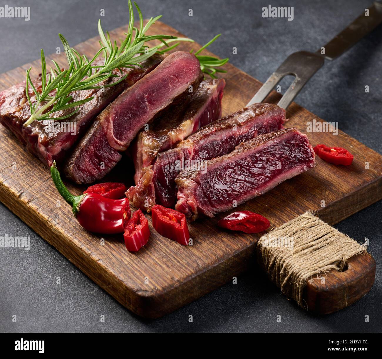 Roasted piece of beef ribeye cut into pieces on a vintage brown ...