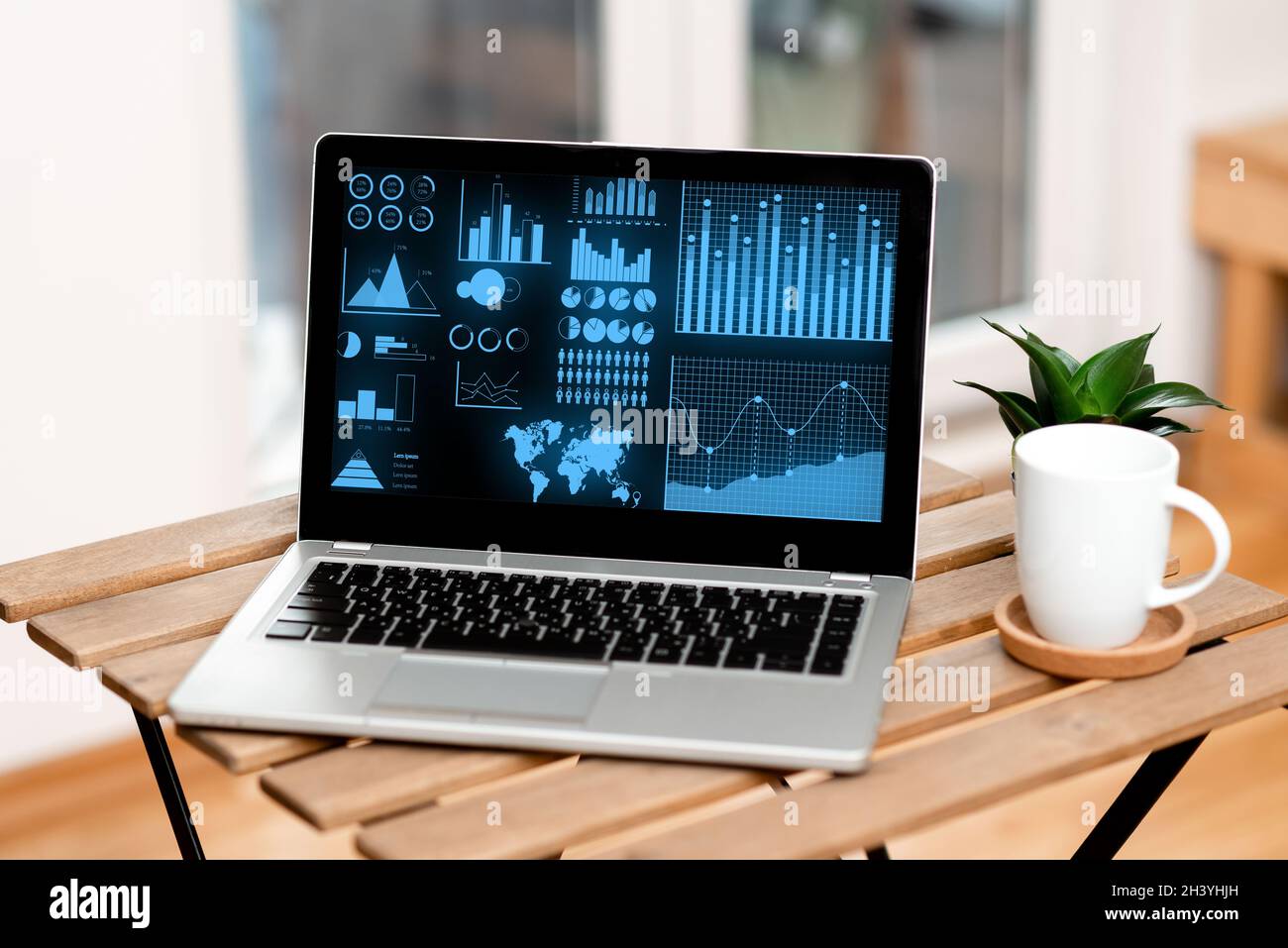 Laptop Resting On A Table Beside Coffee Mug And Plant Showing Work ...