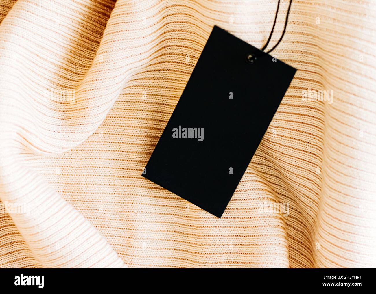Beautiful warm fabric and black price tag as luxury shopping background ...