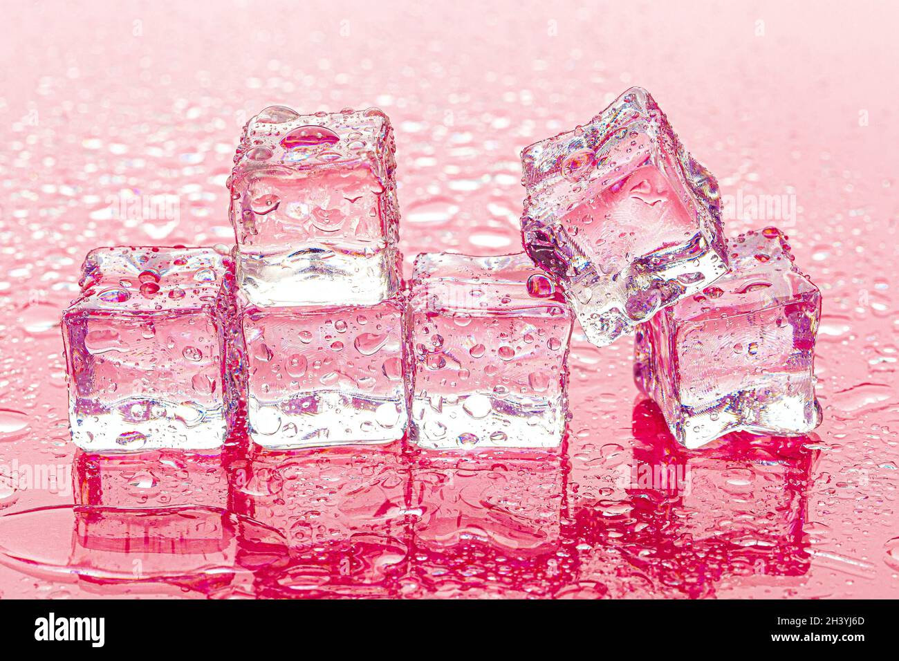 Fozen ice cubes on wet pink background Stock Photo - Alamy