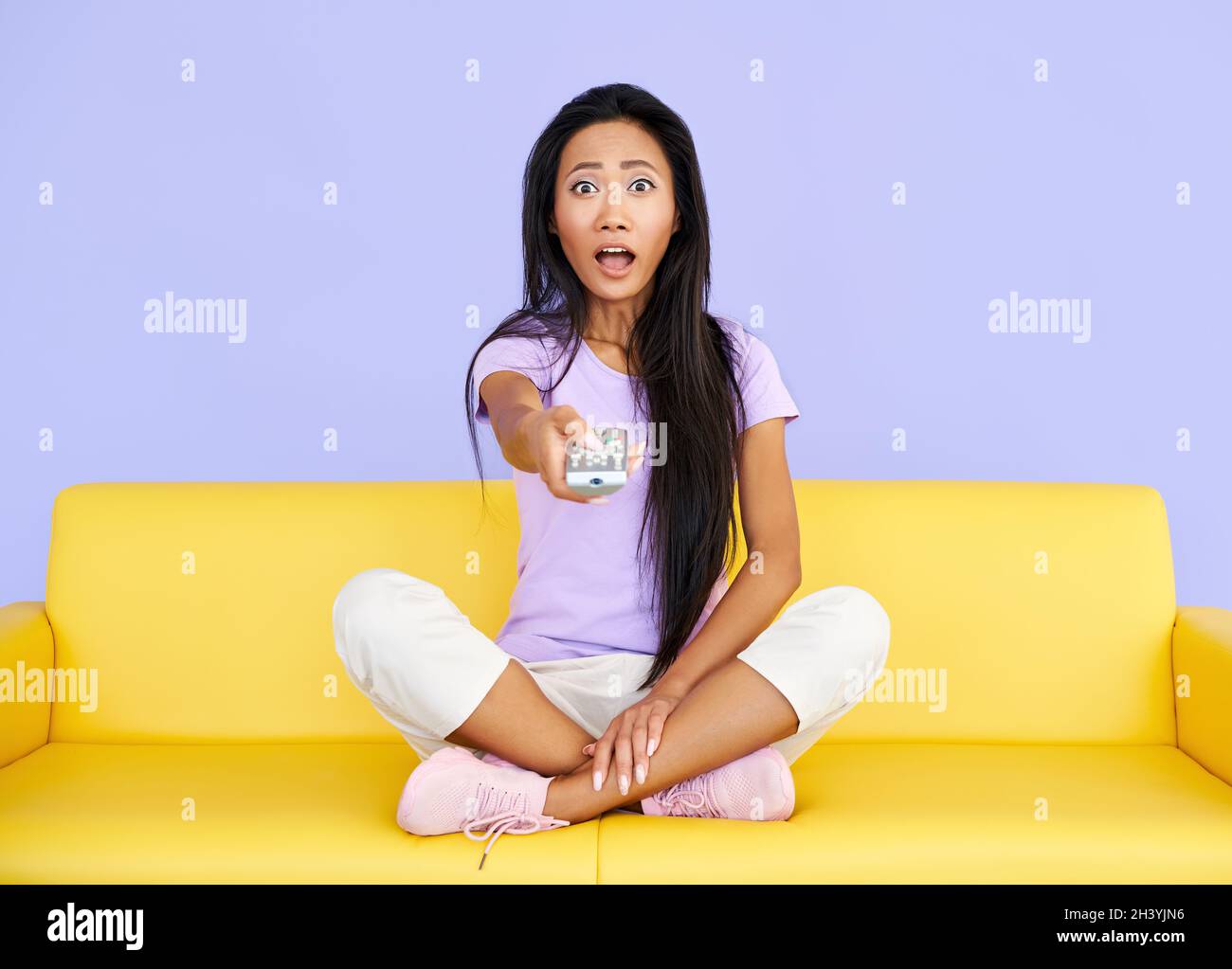Excited surprised woman watch tv changing channel with a remote control ...