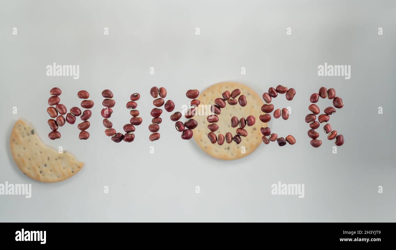 Hunger Word Arranged with Kidney Beans and Biscuits Stock Photo - Alamy