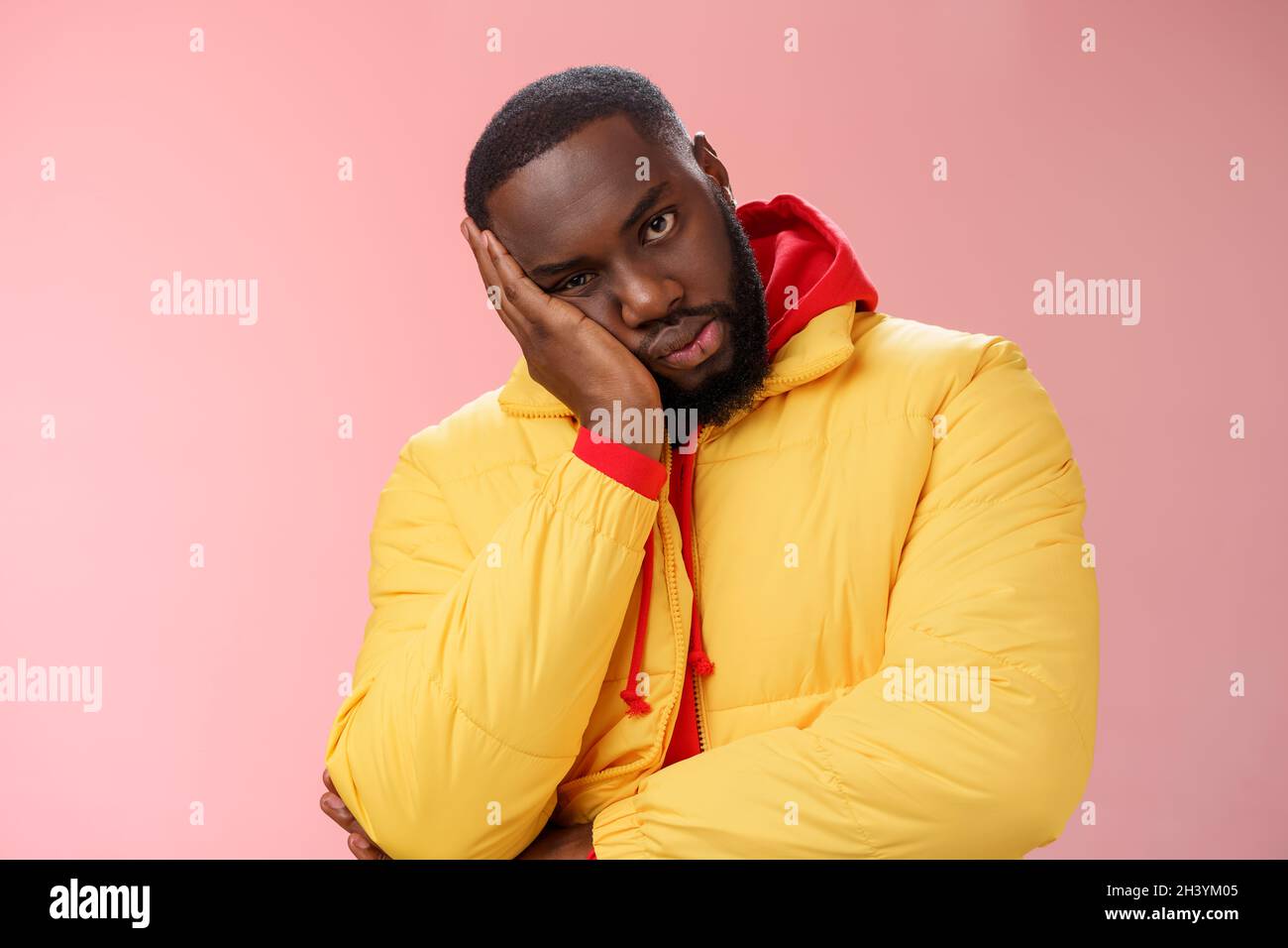 Annoyed bothered pissed african-american bearded man in yellow jacket ...