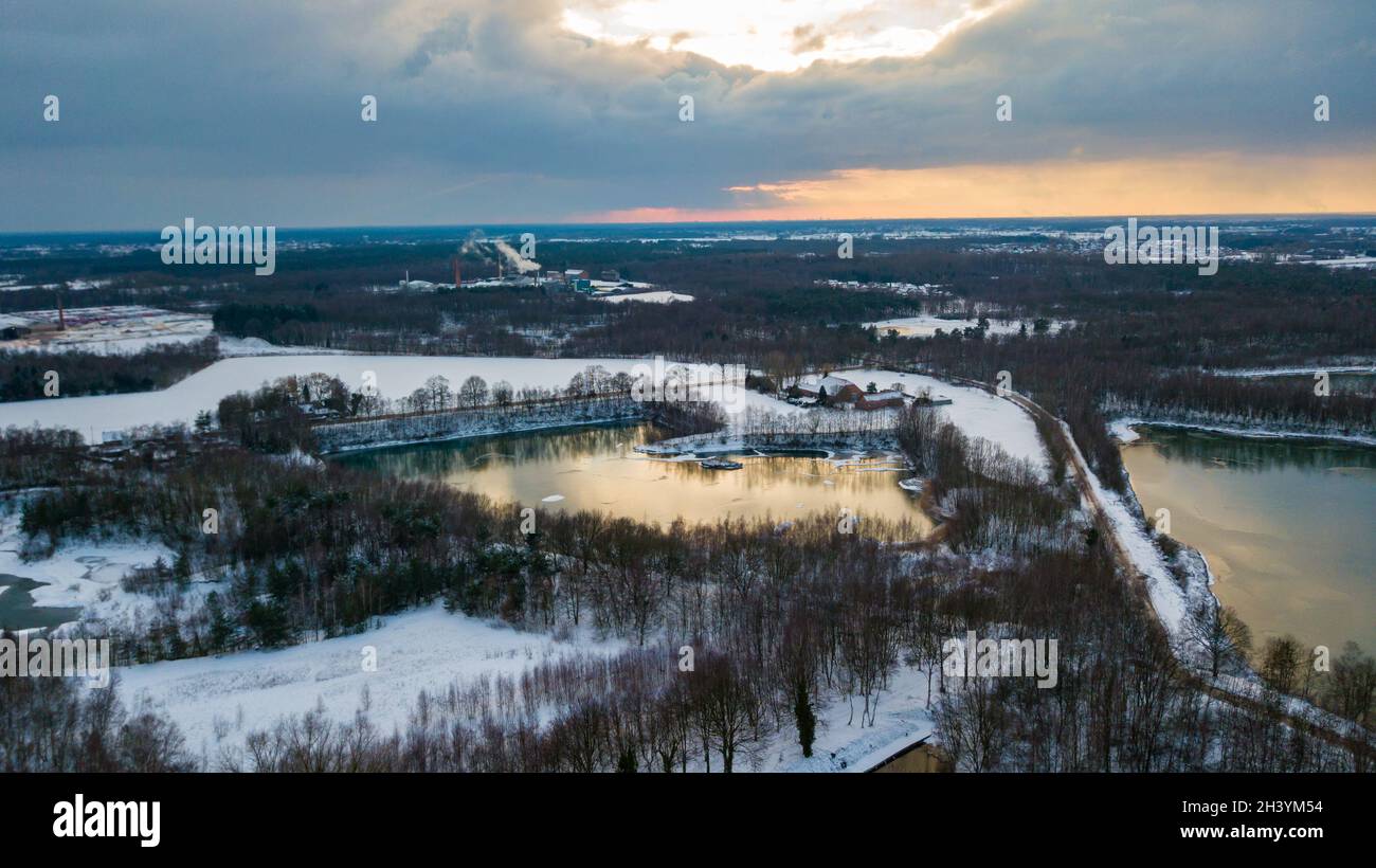 Aerial view of the winter snow covered forest and frozen lake from ...
