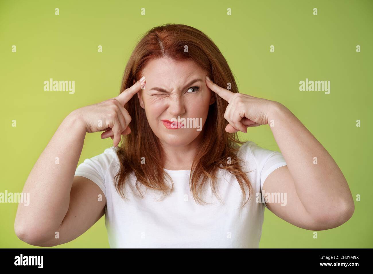 Difficult decision. Perplexed hesitant redhead middle-aged 50s woman ...