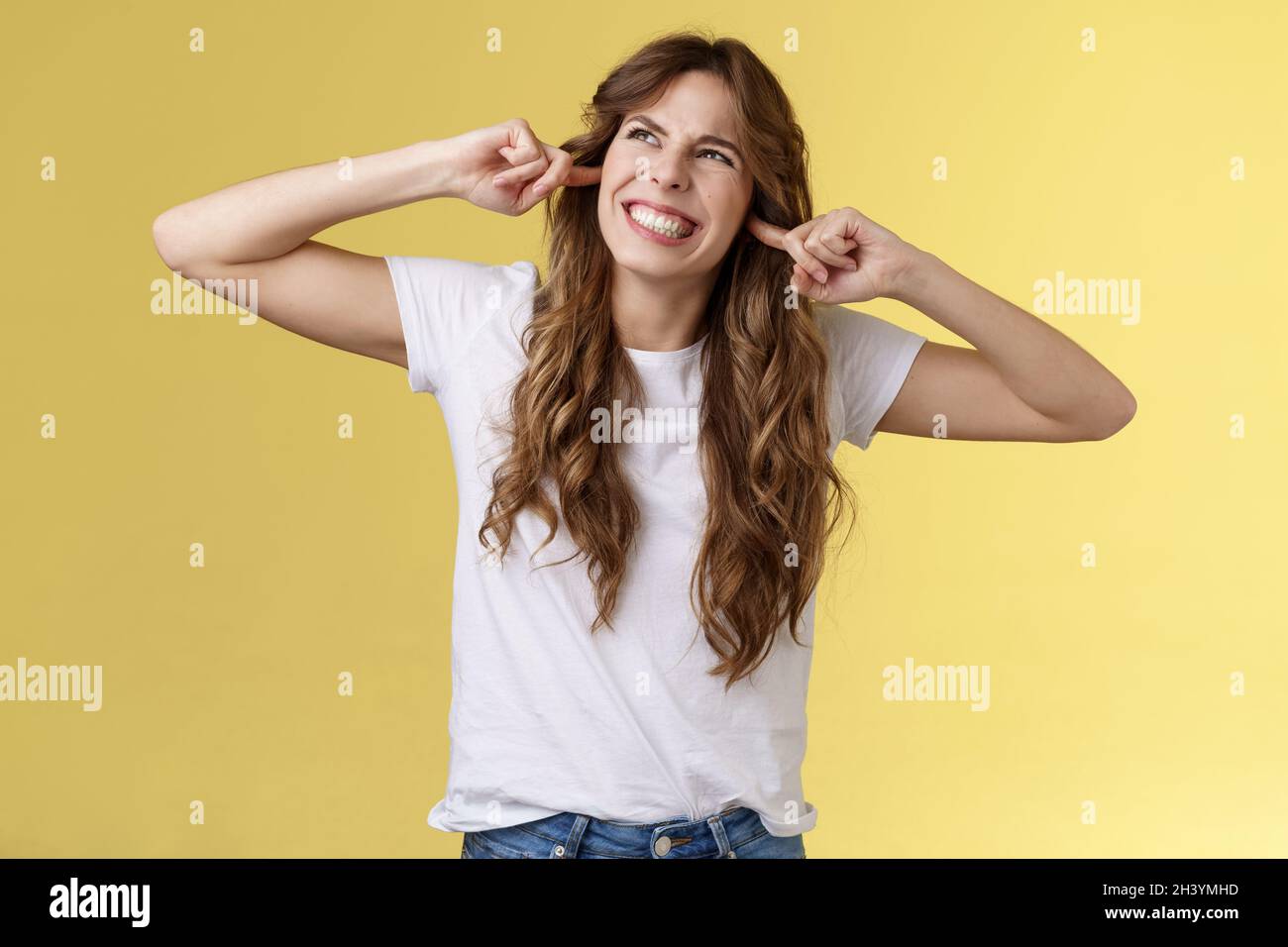 Angry displeased annoyed curly-haired beautiful girl grimacing make wry ...