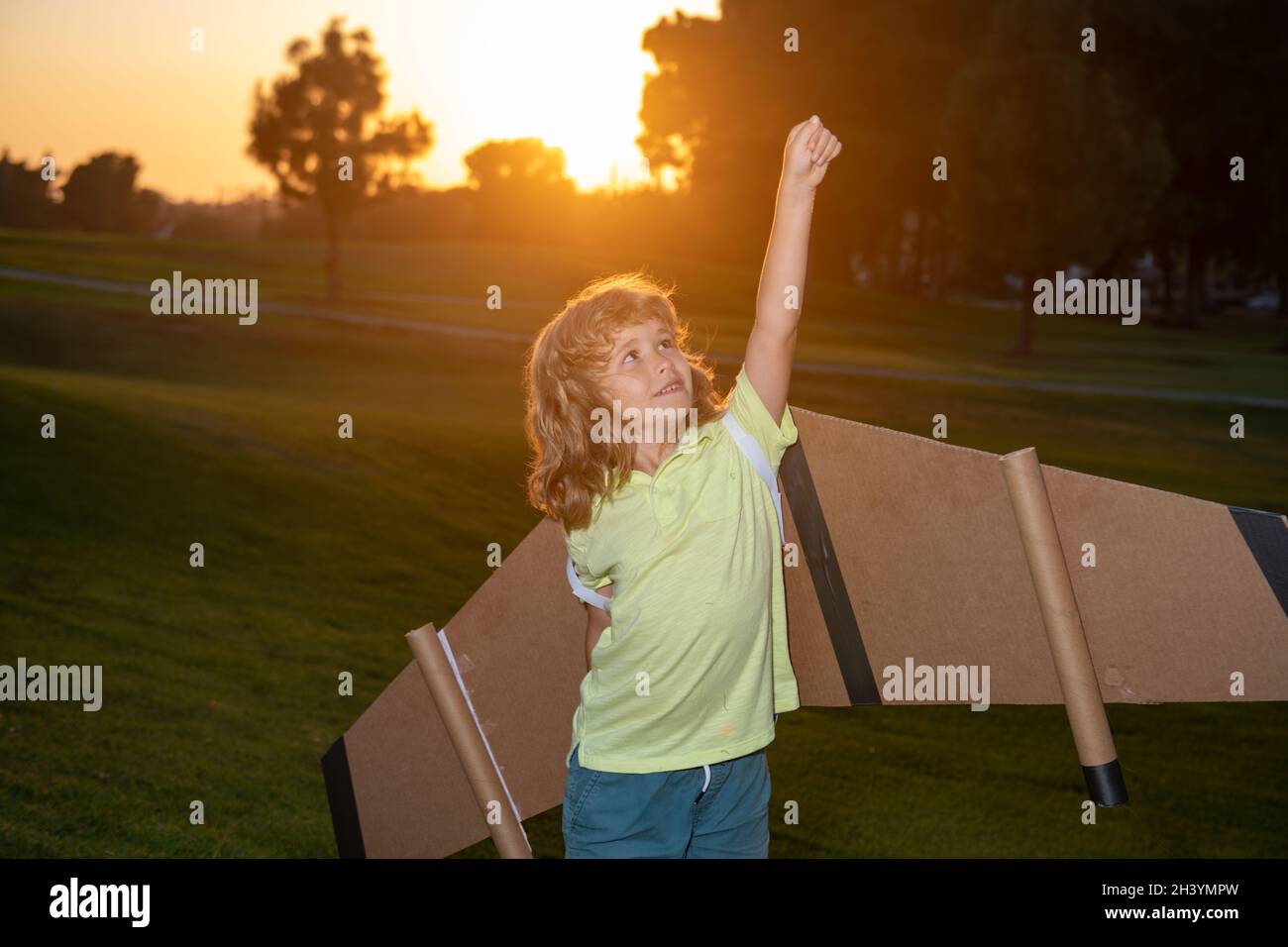 Kid superhero with jetpack. Child pilot play on summer day at sunset ...