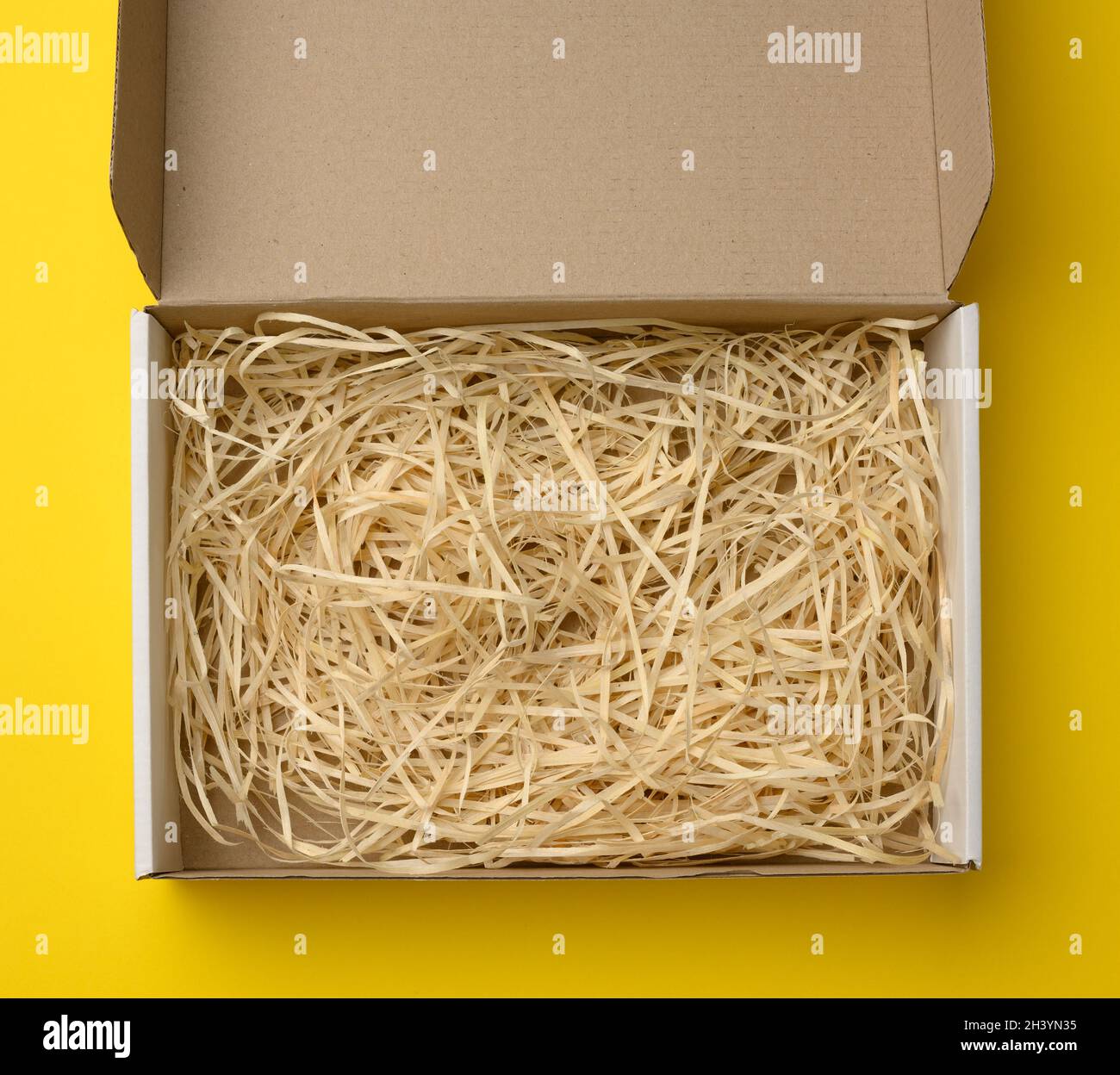 Rectangular open corrugated paper box with sawdust inside. Packaging ...