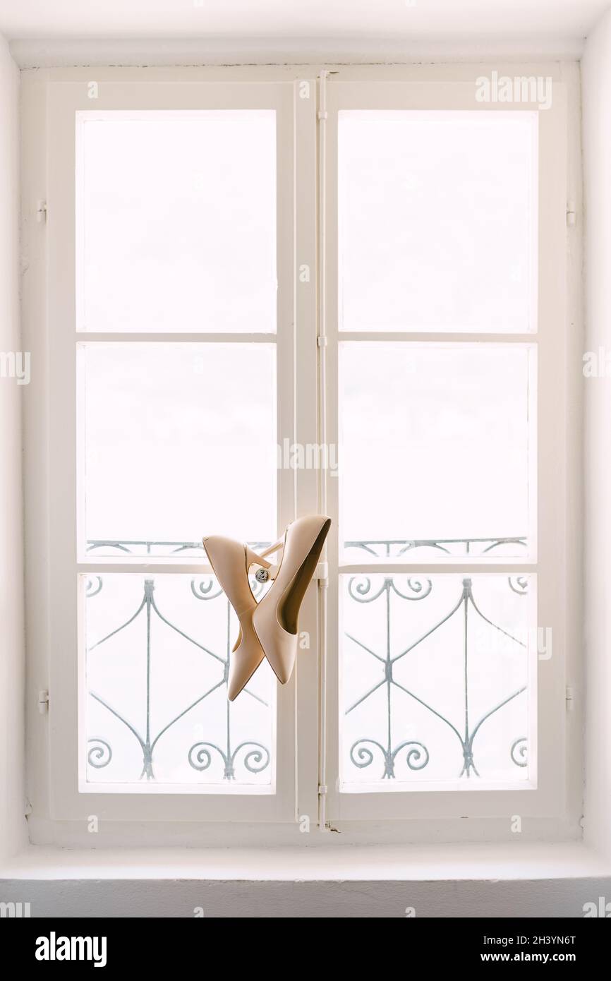 Bride's shoes on the window frame with metal bars Stock Photo - Alamy