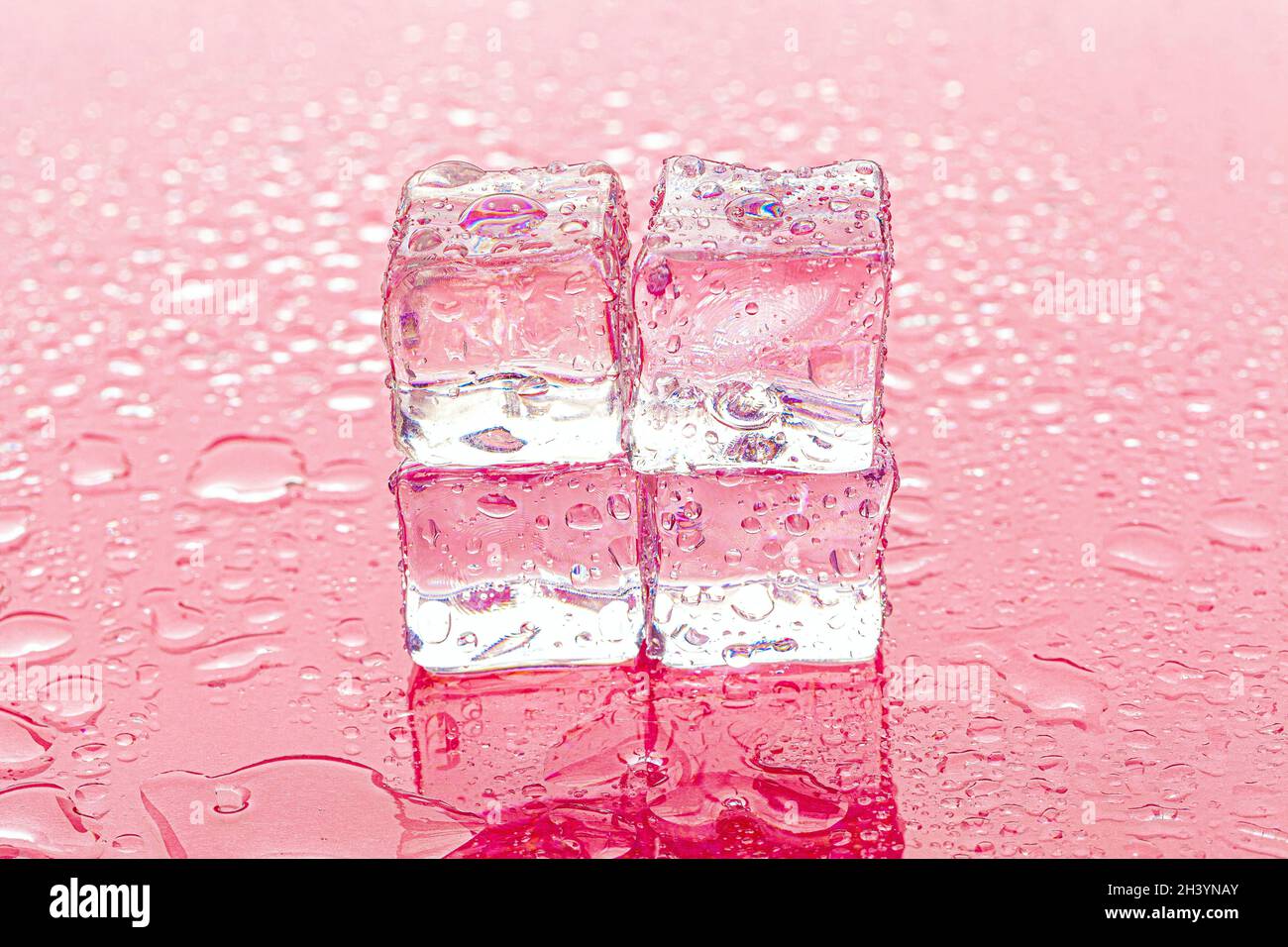 Fozen ice cubes on wet pink background Stock Photo - Alamy